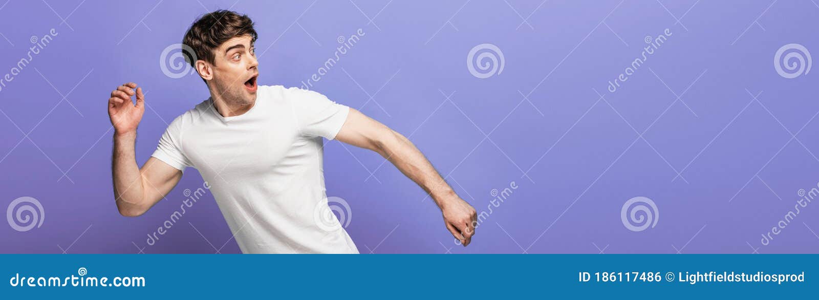 Shot of Scared Young Man Running Away and Looking Back Isolated on Blue ...