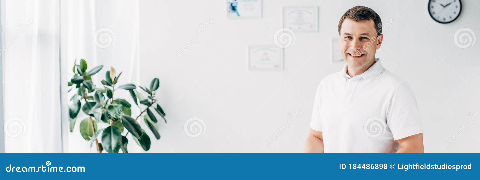 Shot of Smiling Handsome Chiropractor in Hospital Looking at Camera ...