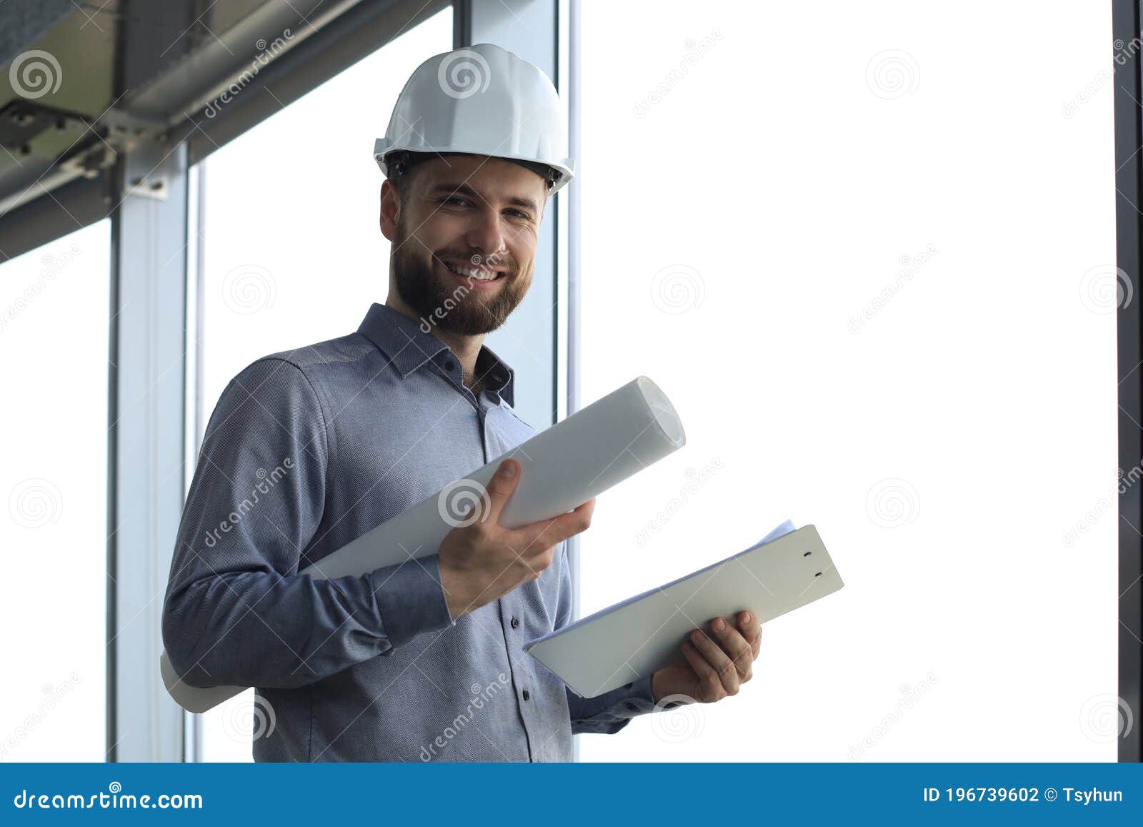 Shot of Smiling Male Architect Wearing Hardhat and Inspecting New ... Shot of Smiling Male Architect Wearing Hardhat and Inspecting New ...
