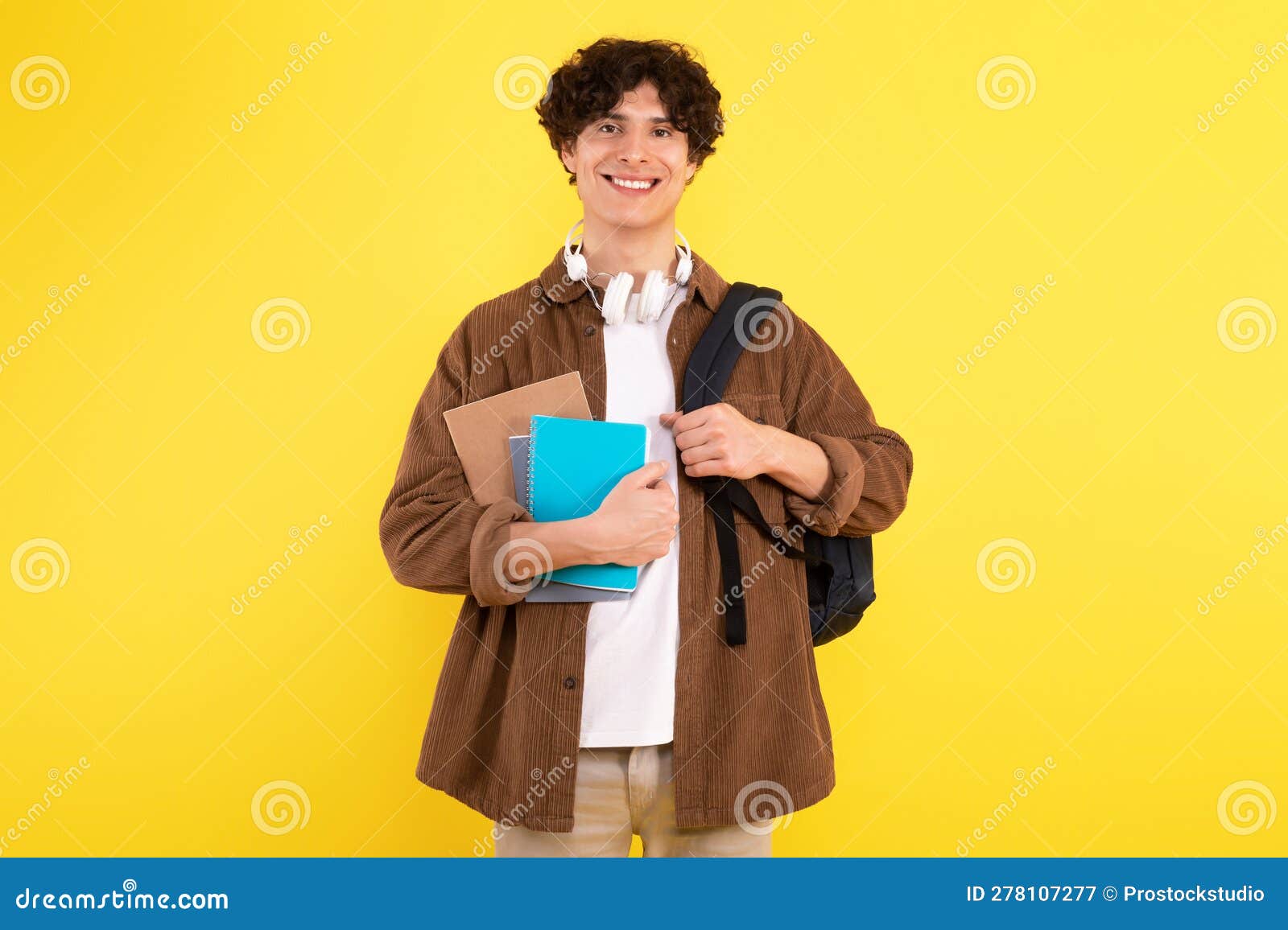 Shot of Smiling Student Guy Posing Over Yellow Studio Background Stock ...