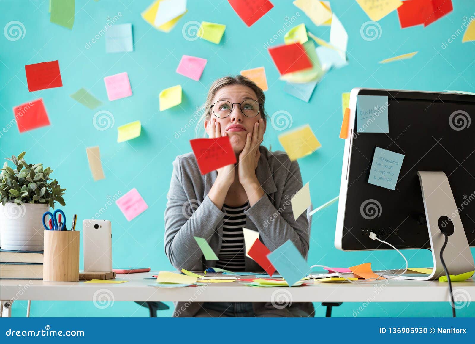 Stressed Young Business Woman Looking Up Surrounded by Post-its in the ... Stressed Young Business Woman Looking Up Surrounded by Post-its in the ...
