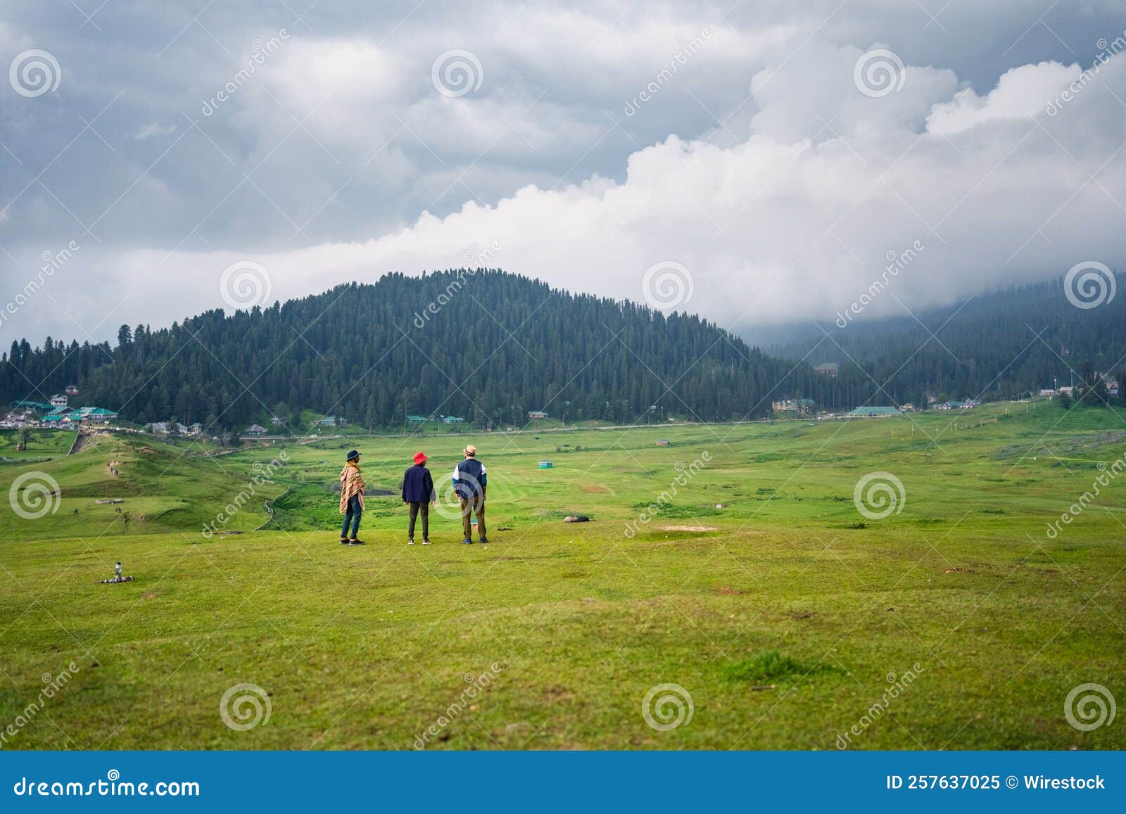 Shot Of Three People Standing On A Grass Field Surrounded By Hills Stock Image Image Of