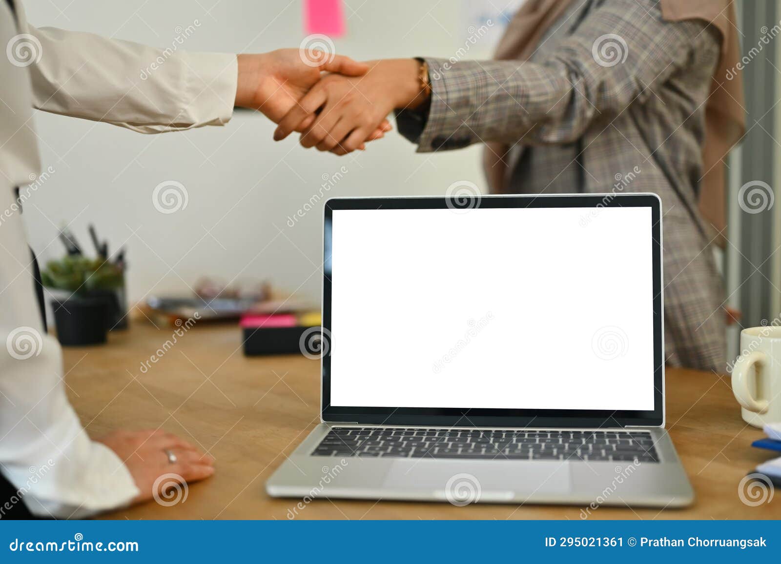 Shot of Two Businesspeople Shaking Hands Over Laptop Computer with ...