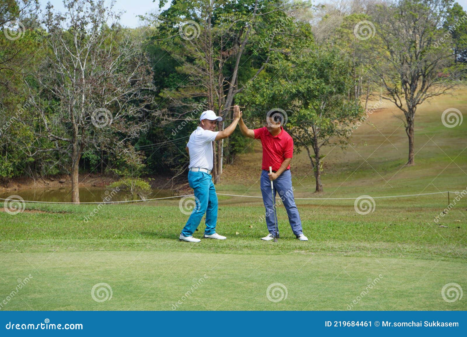 Shot of Two Golfers Congratulating Each Other with a High Five after a ...
