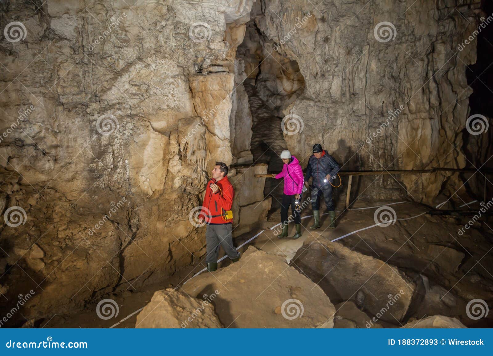 Shot of Two Tourists and a Tourist Guide Walking in the Cave Stock ...