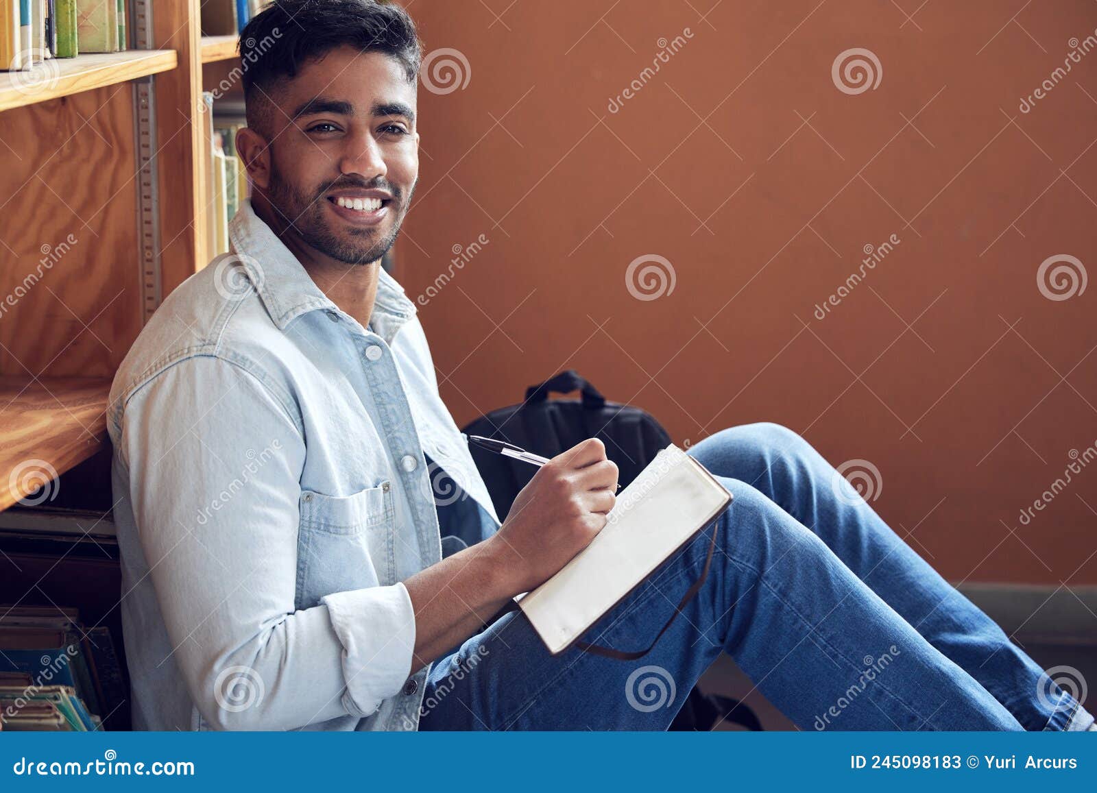 Revision Done Right. Shot of a Young Man Making Notes in a Library at ...