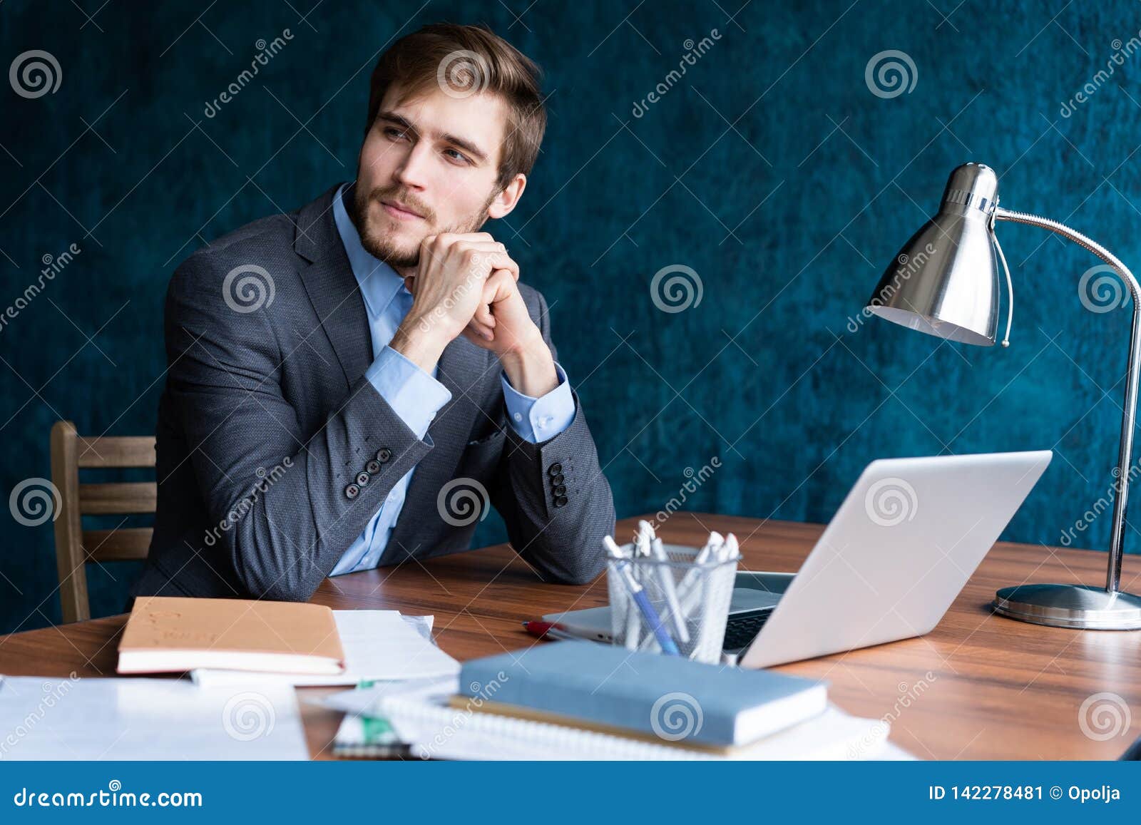 Shot of Young Man Sitting at Table Looking Away and Thinking ... Shot of Young Man Sitting at Table Looking Away and Thinking ...