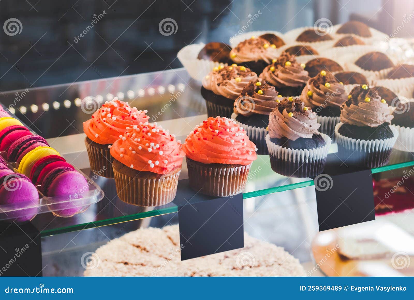 Showcase with Sweets in the Cafe. Cupcakes and Colored Macaroons on the ...