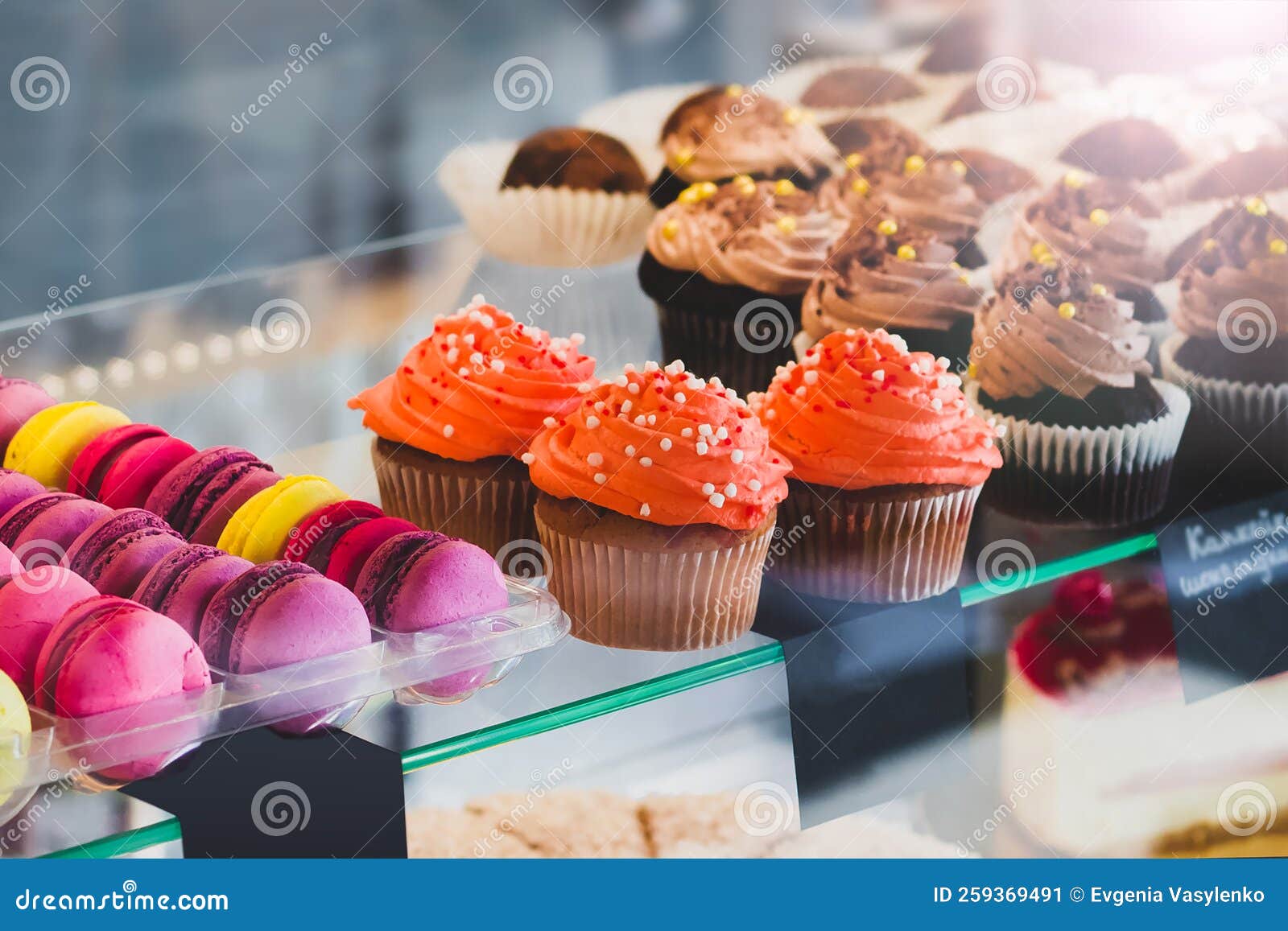 Showcase with Sweets in the Cafe. Cupcakes and Colored Macaroons on the ...