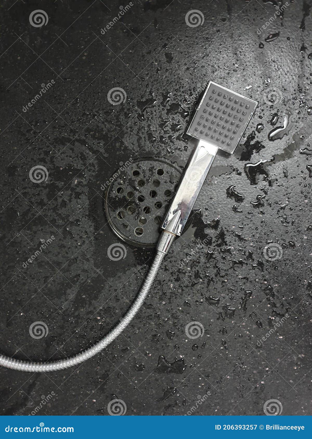 Shower Head Laying on Natural Stone Floor and Gutter with Drops of ...
