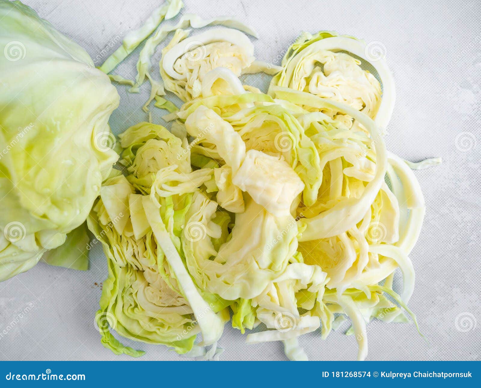Shredded Cabbage with a Paring Knife on a White Plastic Chopping Board ...