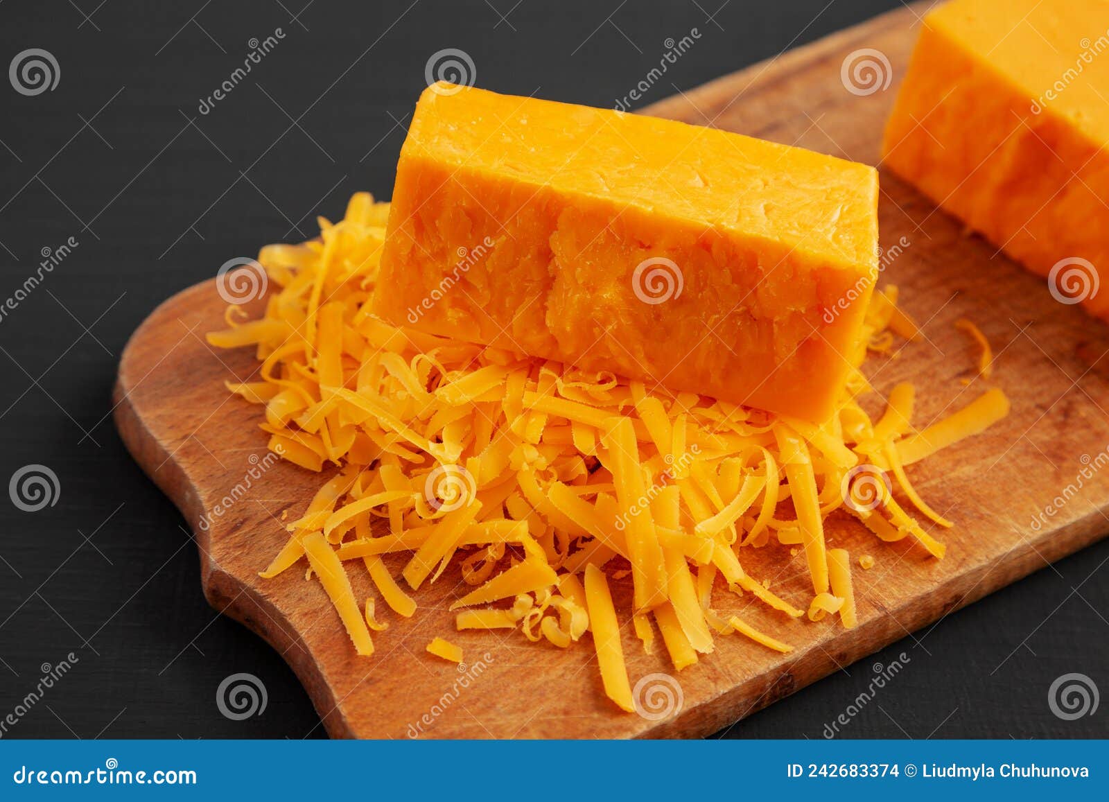 Shredded Sharp Cheddar Cheese on a Rustic Wooden Board on a Black ...