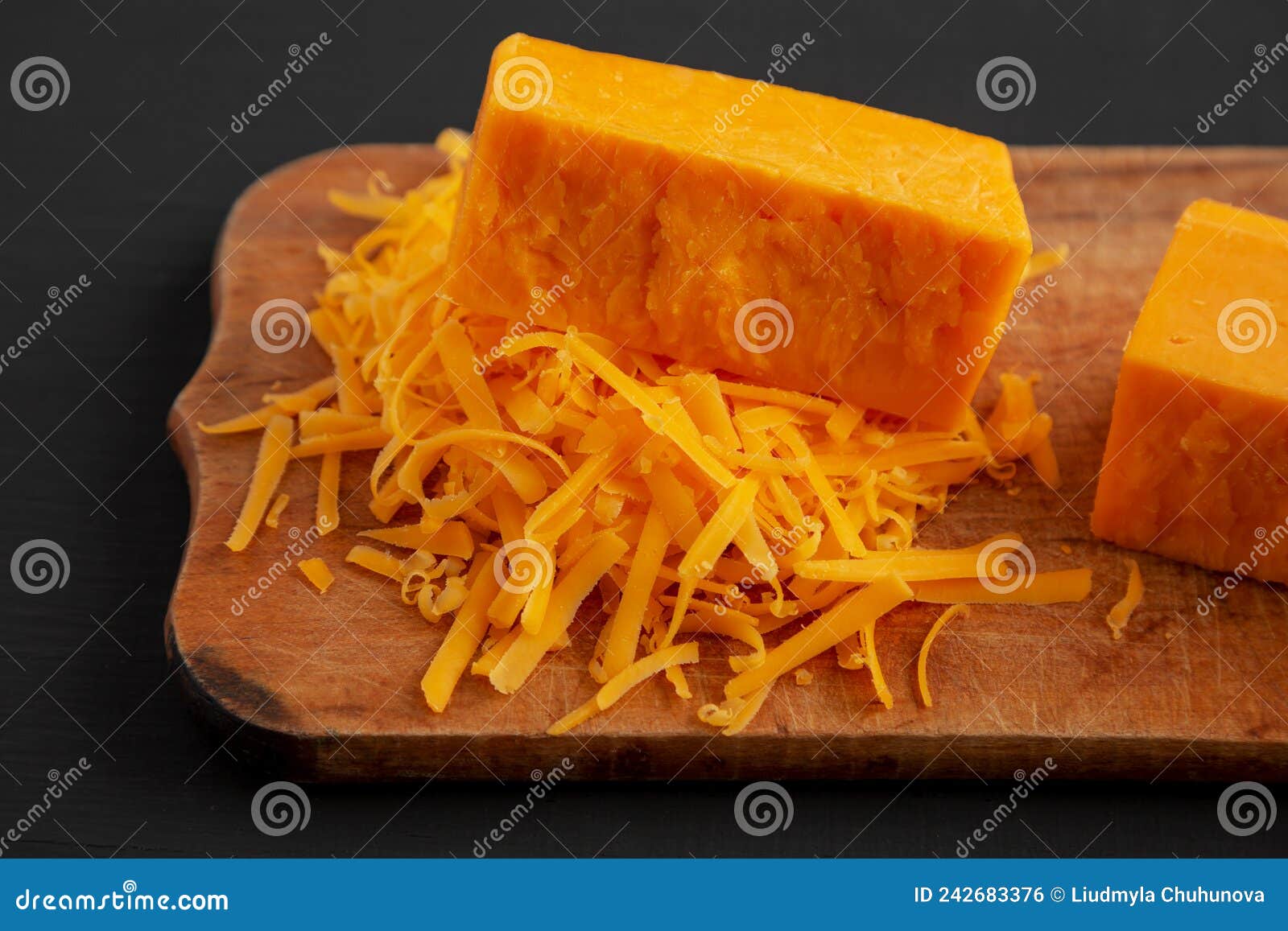 Shredded Sharp Cheddar Cheese on a Rustic Wooden Board on a Black ...