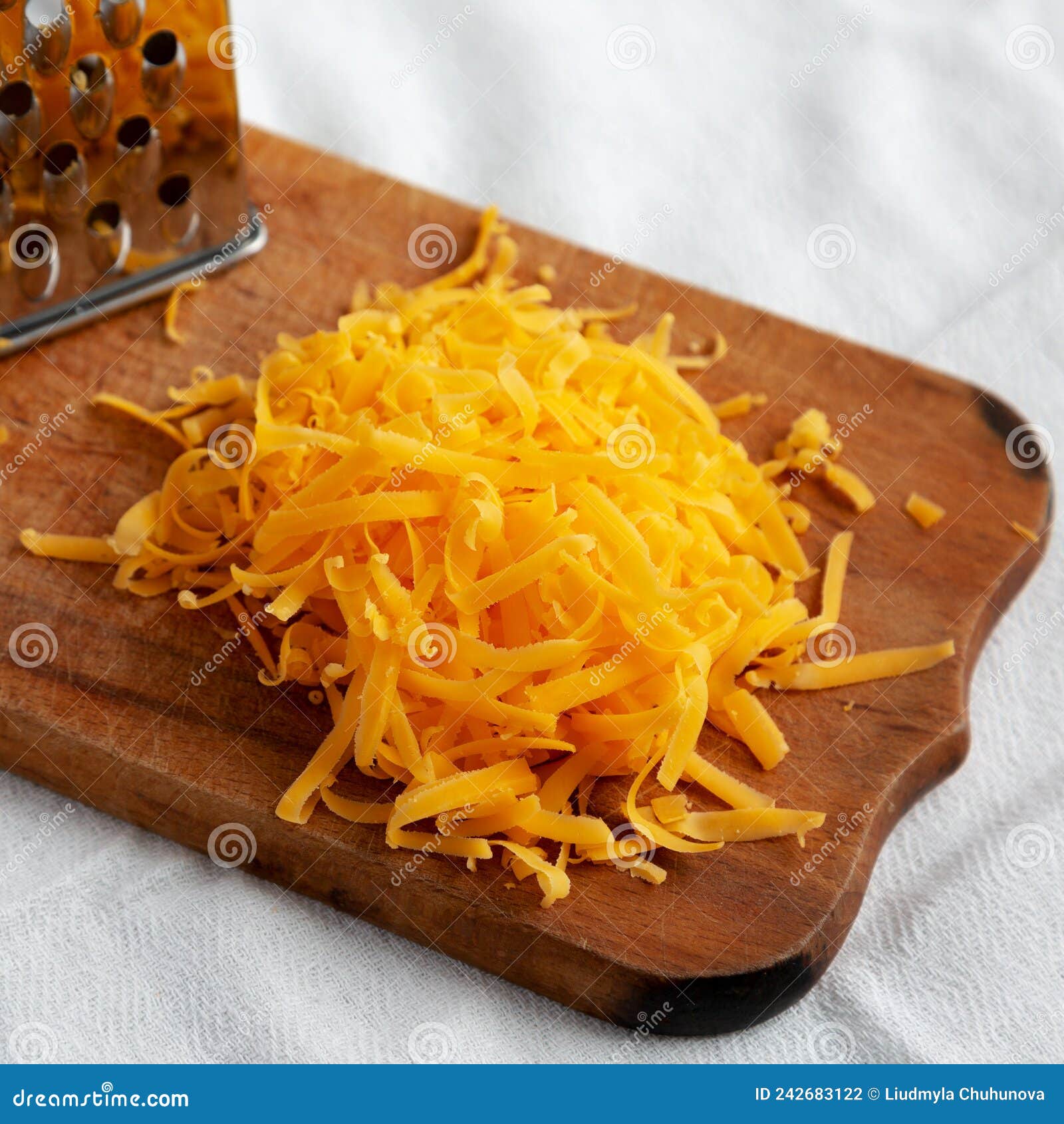 Shredded Sharp Cheddar Cheese on a Rustic Wooden Board, Low Angle View ...