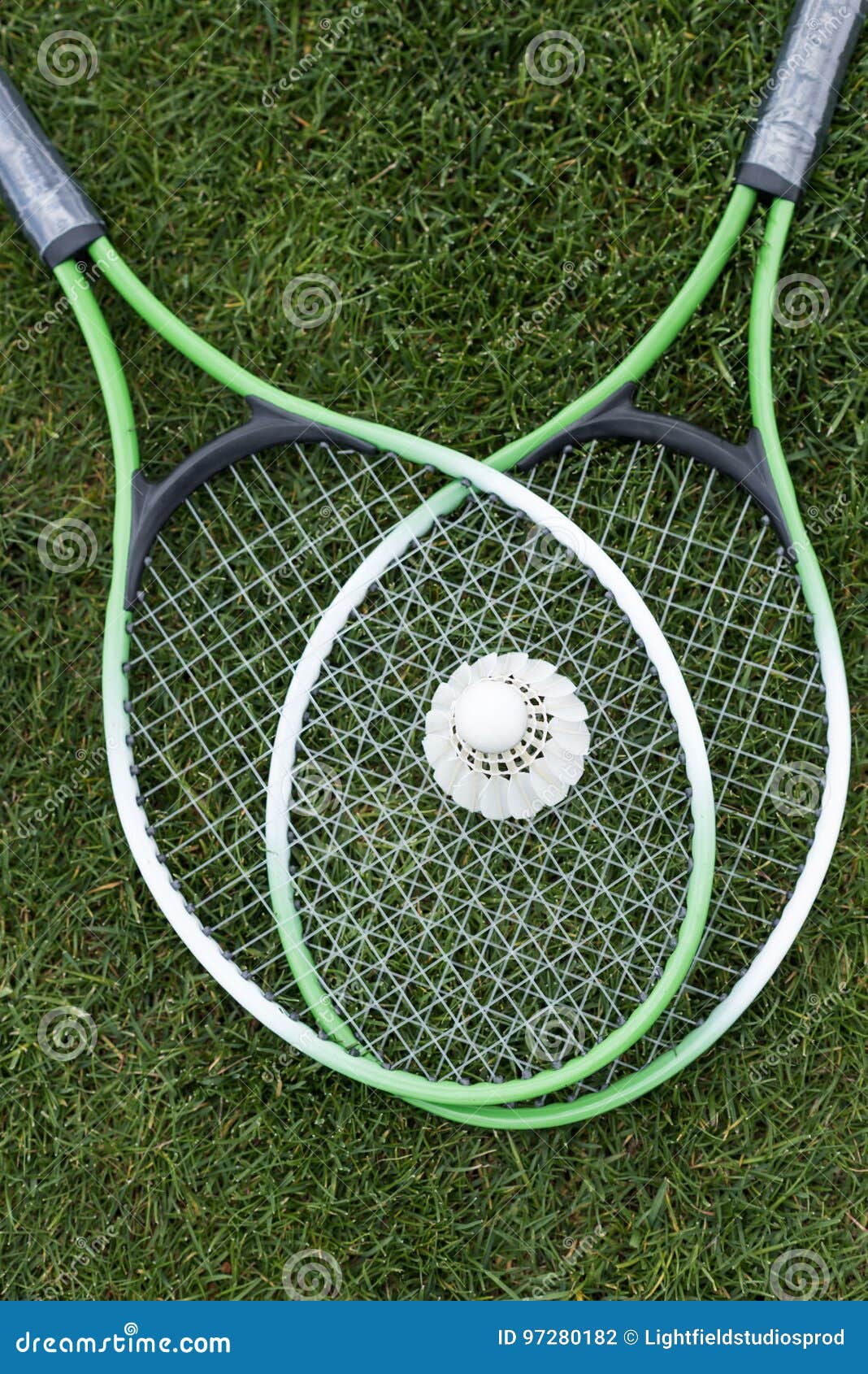 Shuttlecock on Badminton Rackets Lying on Green Grass Stock Photo ...
