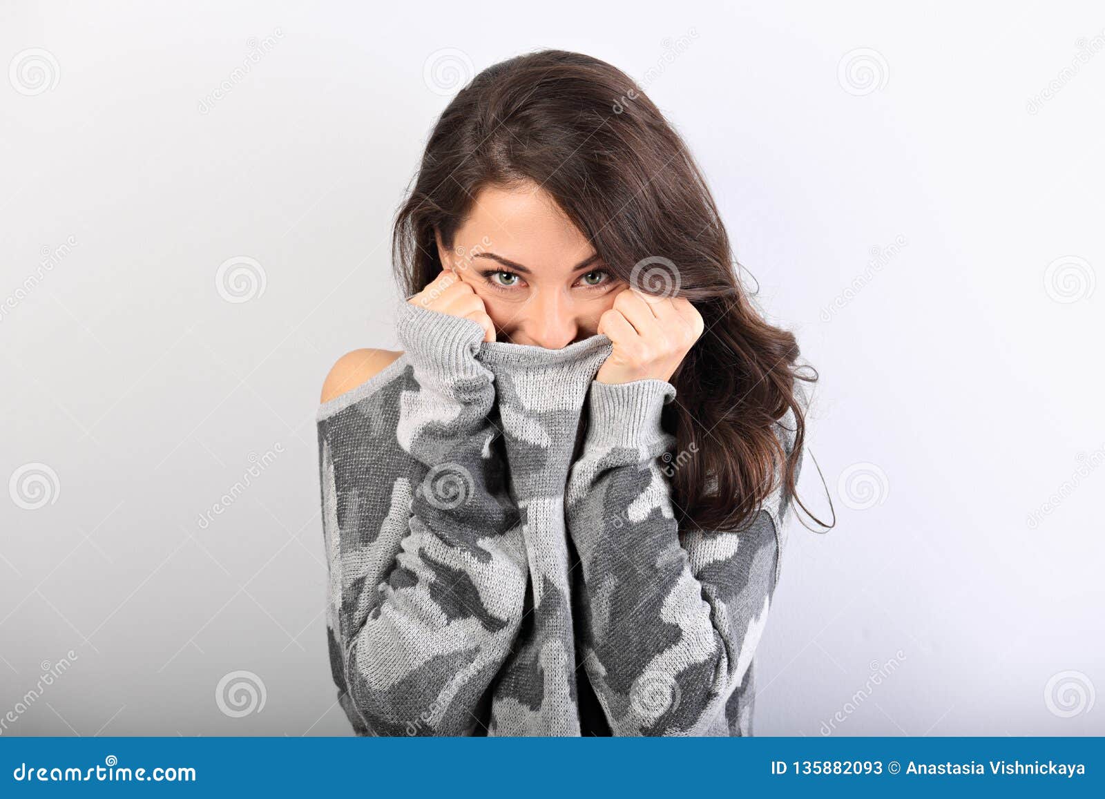 Shy Joying Woman Hiding Her Face Inside The Grey Warm Winter Pullover