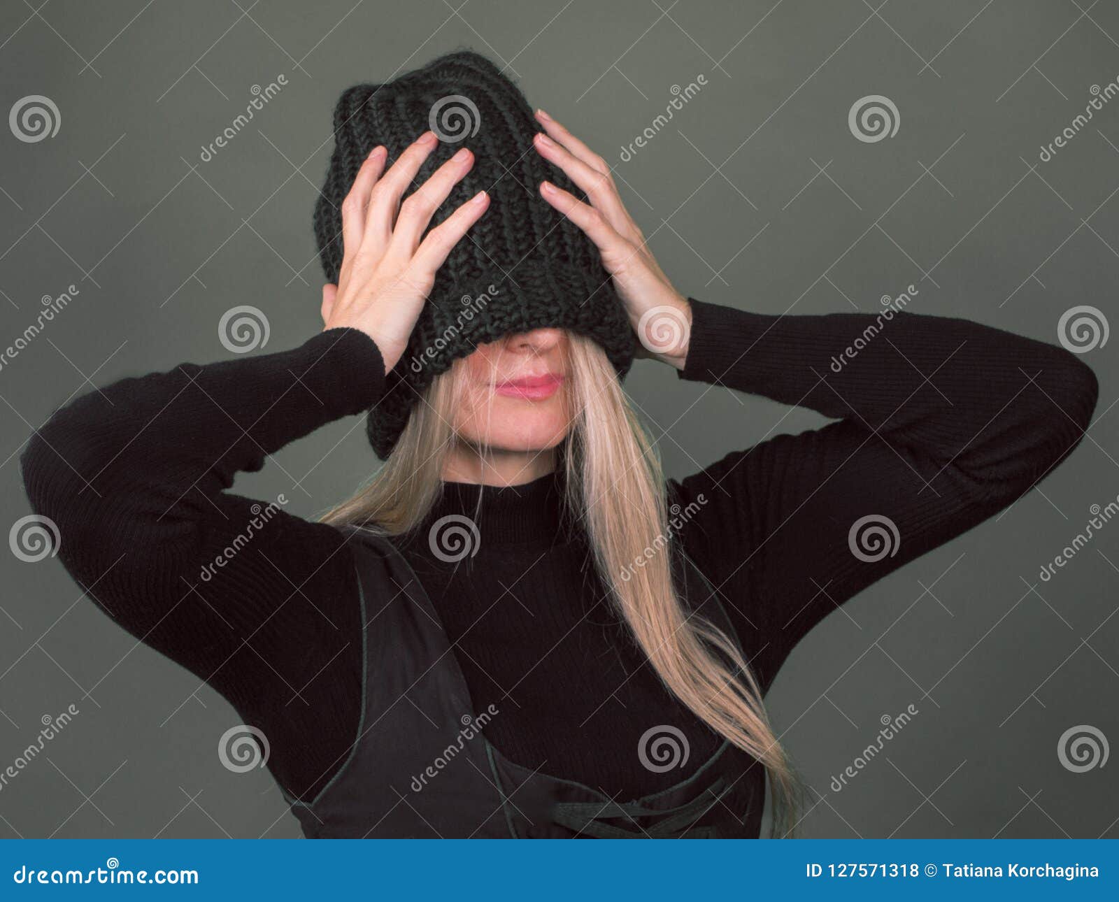 A Shy Woman Pulls Her a Knitted Hat Over Her Face. Stock Photo - Image ...