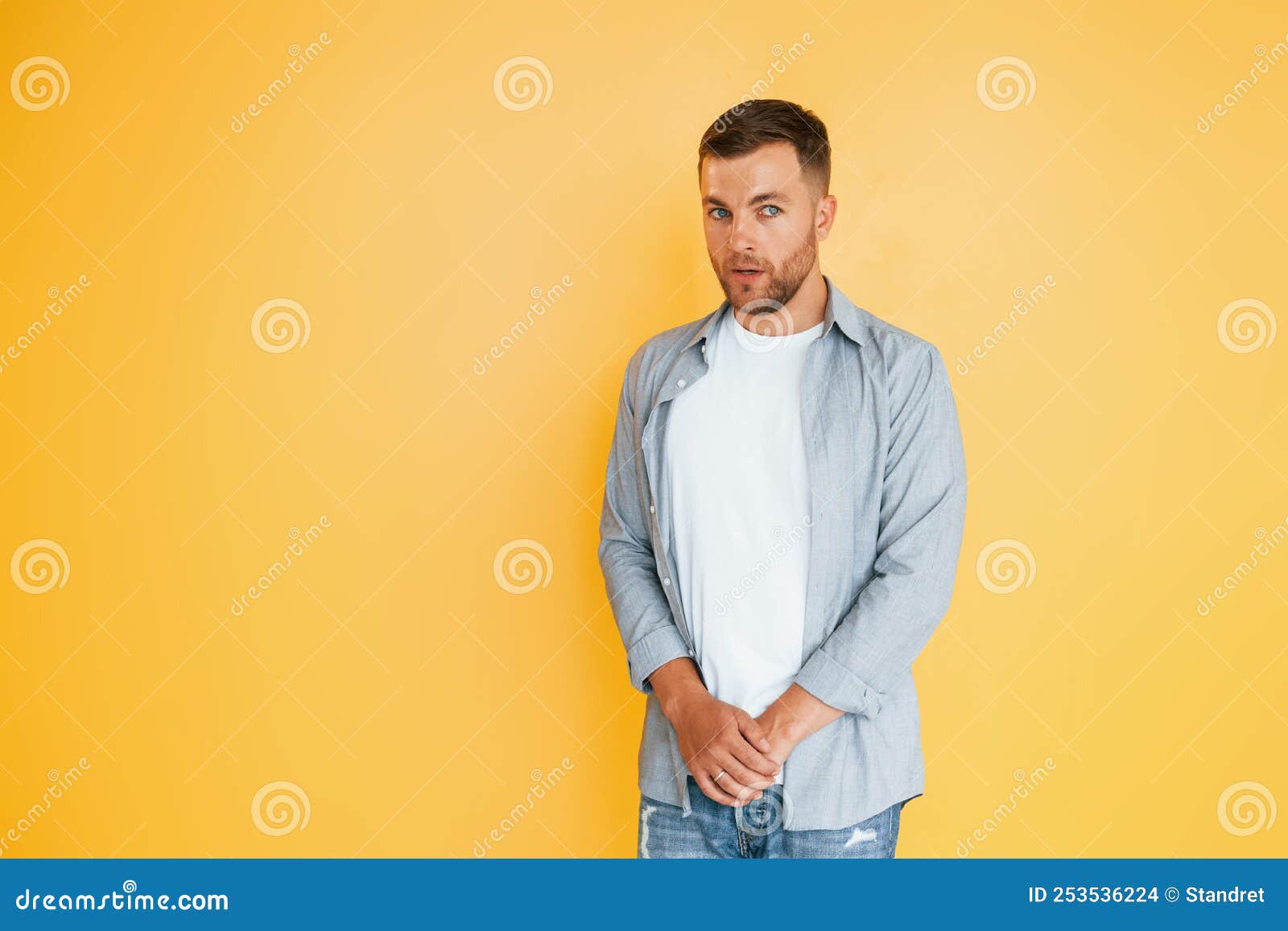 Shy Young Man in Casual Clothes Standing Indoors in the Studio Stock ...