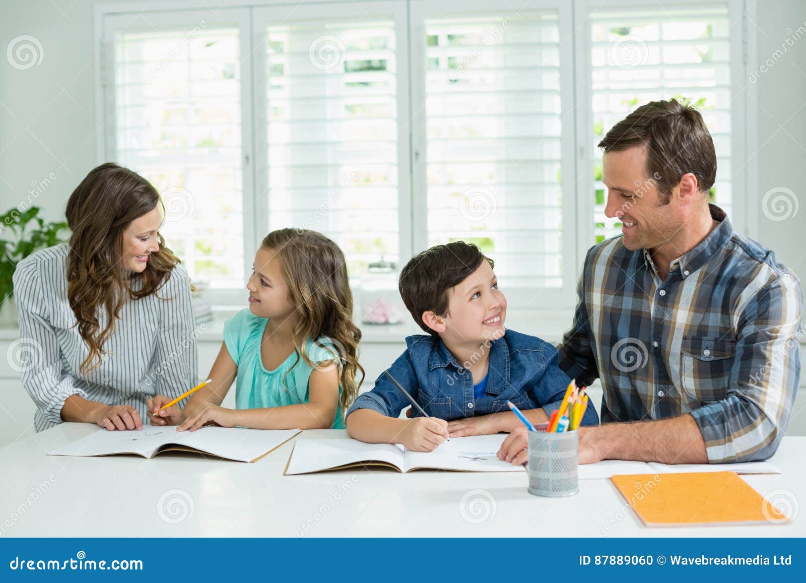 Siblings Getting Help with Homework from Parents Stock Photo - Image of ...