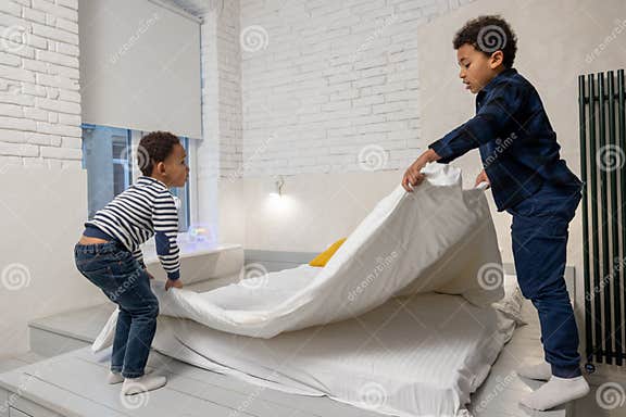 Siblings Making Bed Together and Fixing a Flock Bed Stock Photo - Image ...