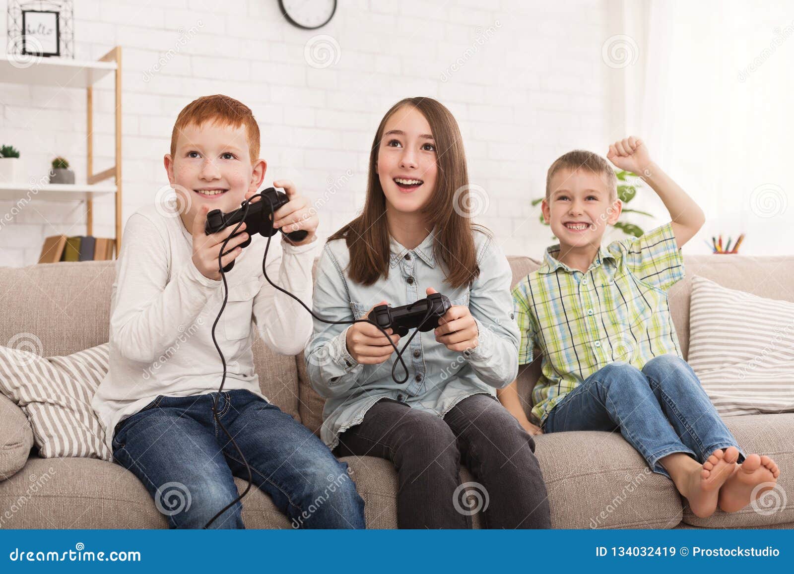 Siblings Playing Game Console while Boy Cheering for Them Stock Image ...