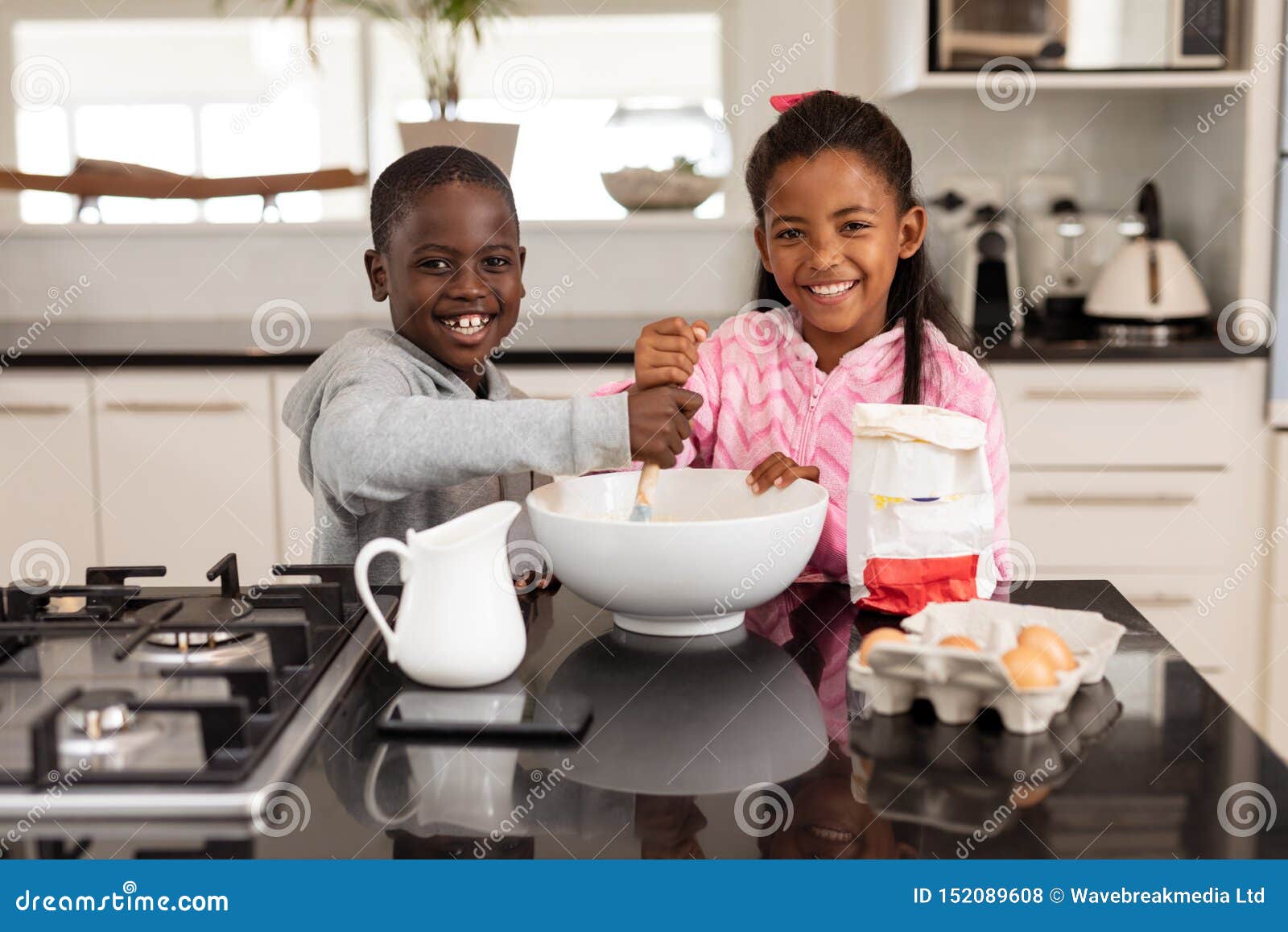 Siblings Preparing Food on a Dining Table in Kitchen at Home Stock ...