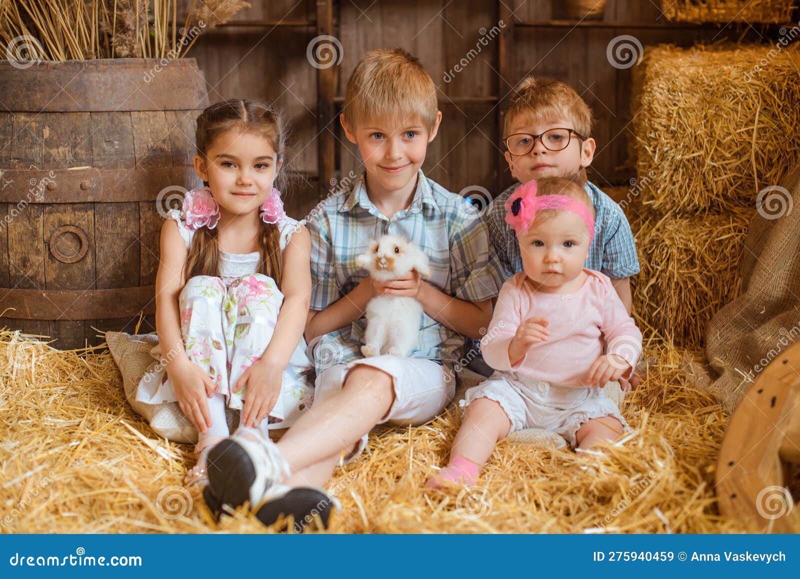 Siblings Sit on Hay in a Rustic Barn Surrounded by Wooden Boxes and a ...