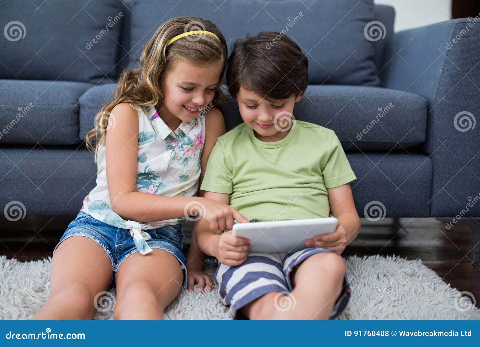 Siblings Using Digital Tablet in Living Room Stock Photo - Image of ...