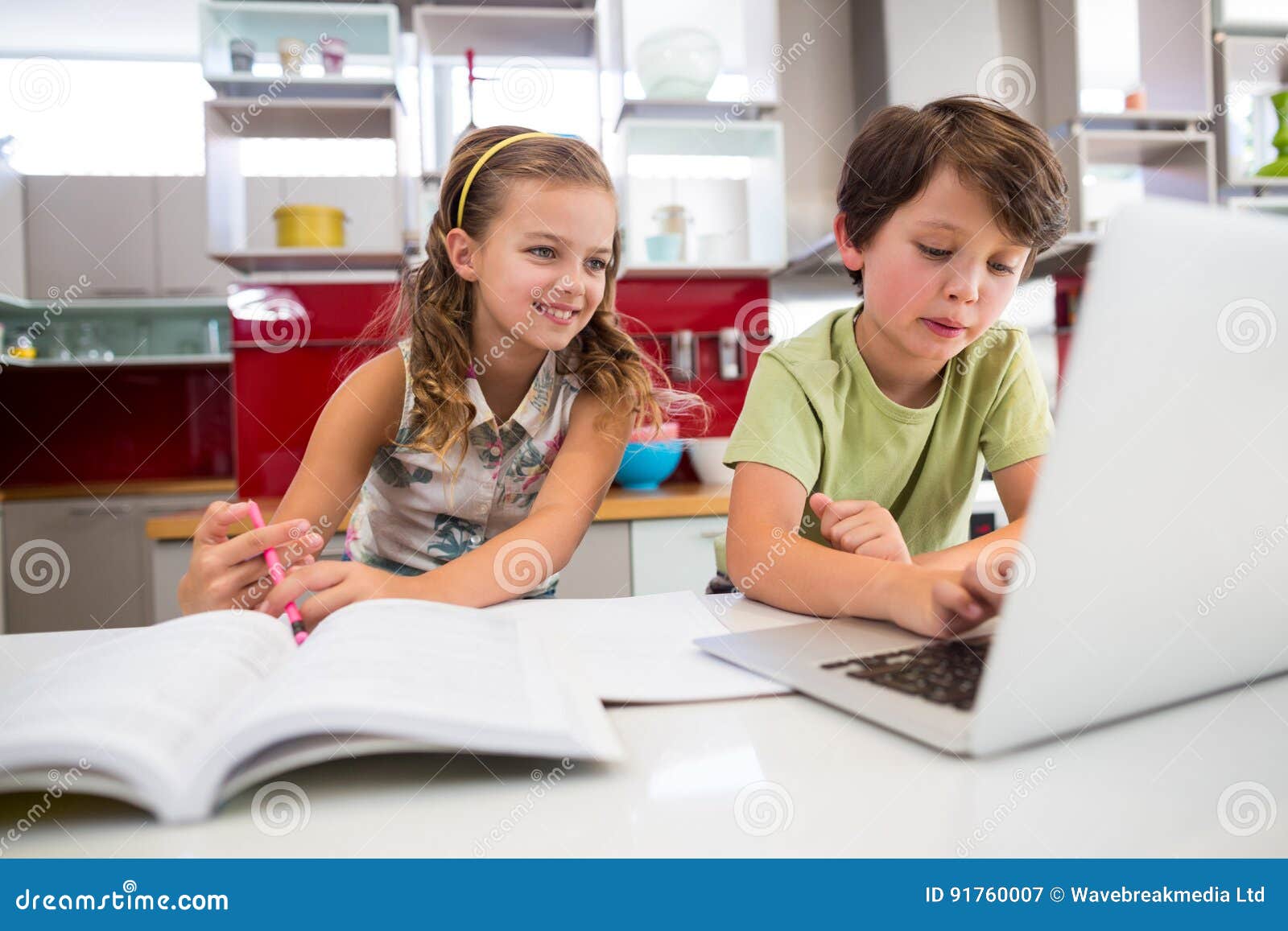 Siblings Using Laptop while Doing Homework in Kitchen Stock Image ...