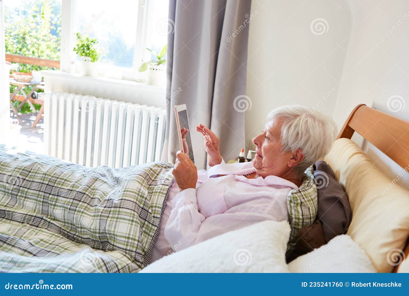 Sick Elderly Woman in Bed in the Retirement Home while Video Chat Stock ...