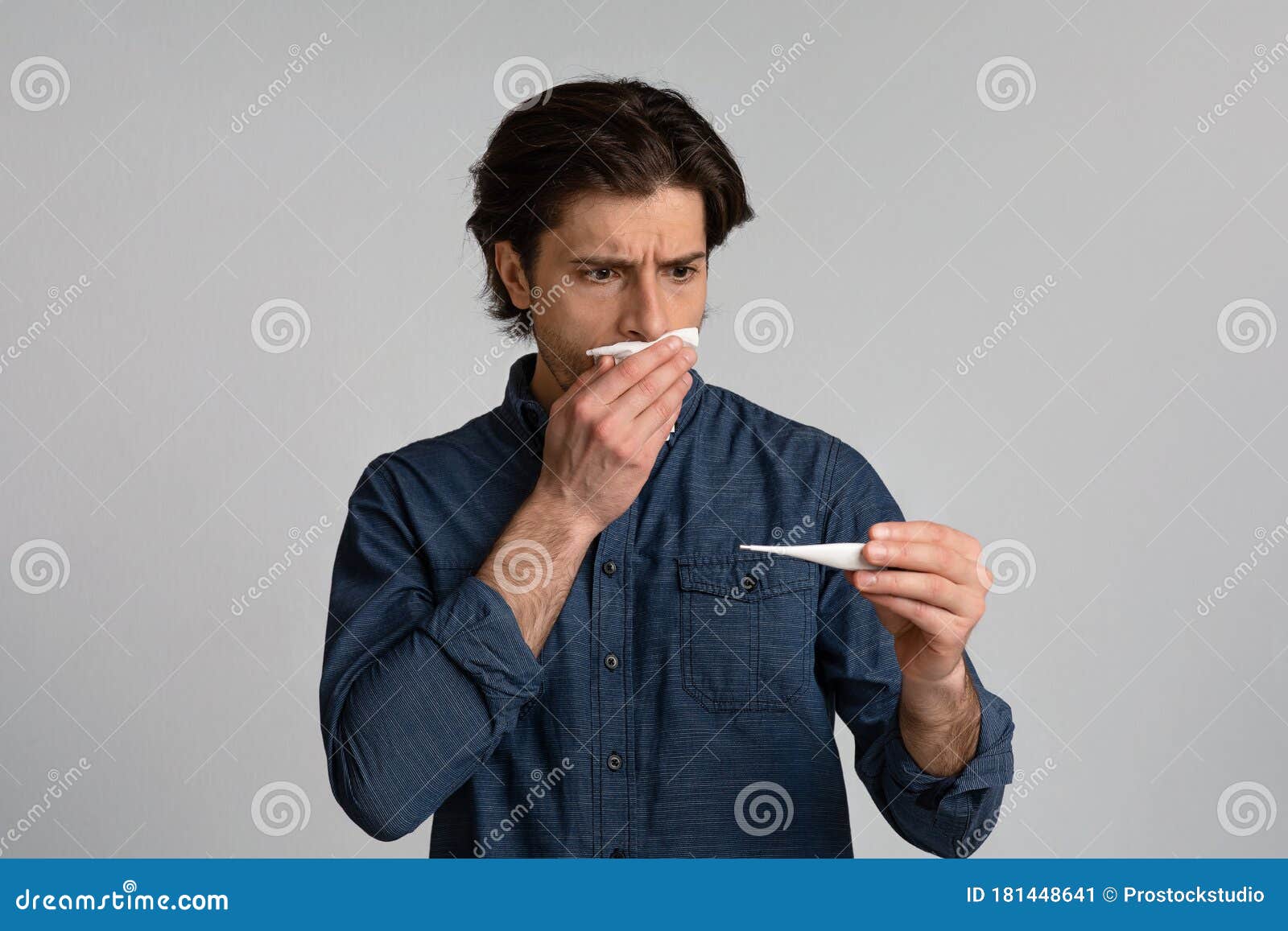 Sick Man Holding Thermometer Checking His High Temperature Over Light