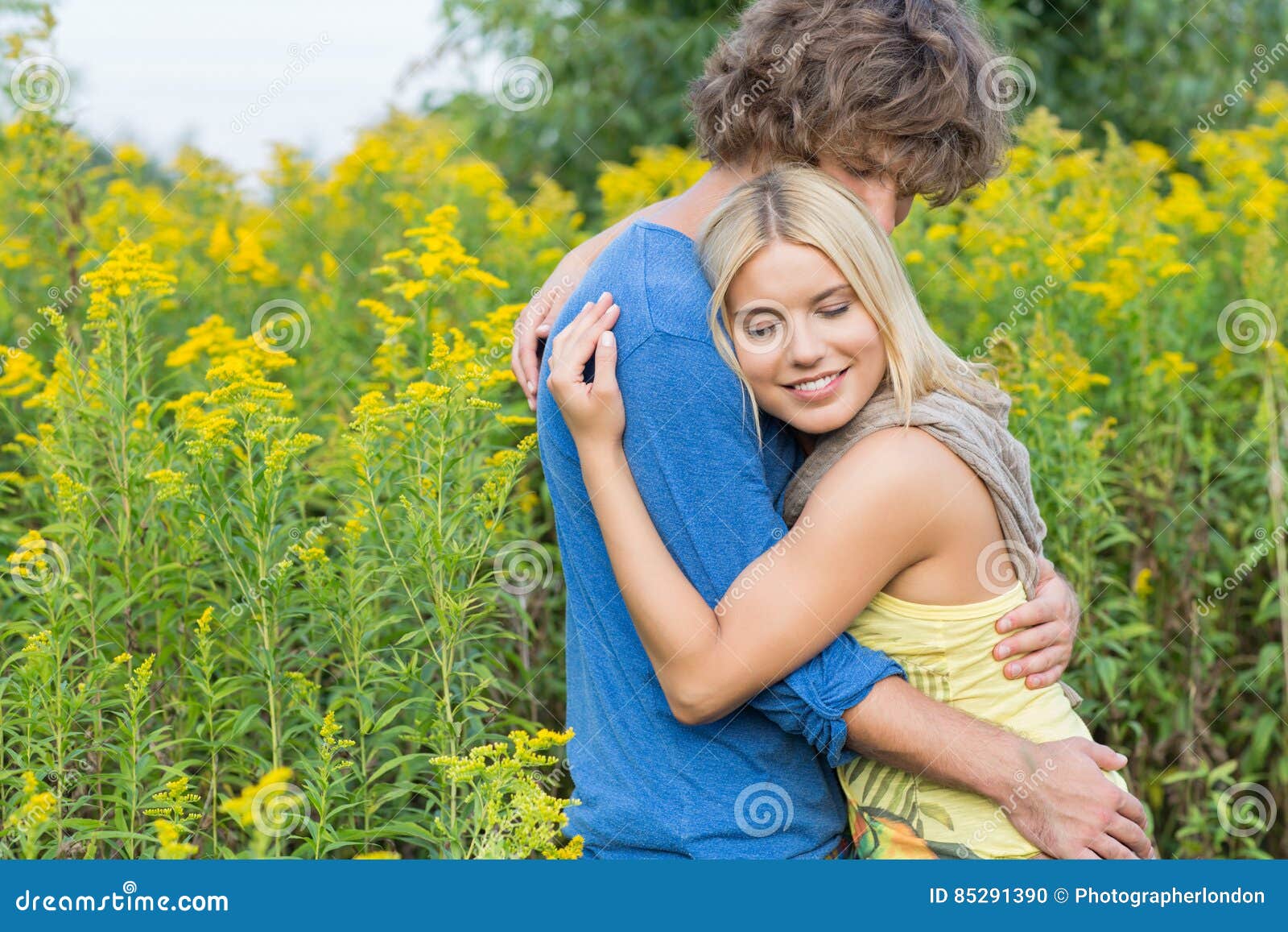 Side View of Affectionate Couple Hugging in Field Stock Photo - Image ...