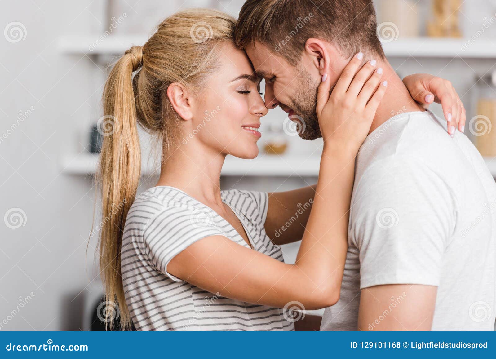 Side View of Affectionate Couple Hugging in Kitchen and Touching Stock ...