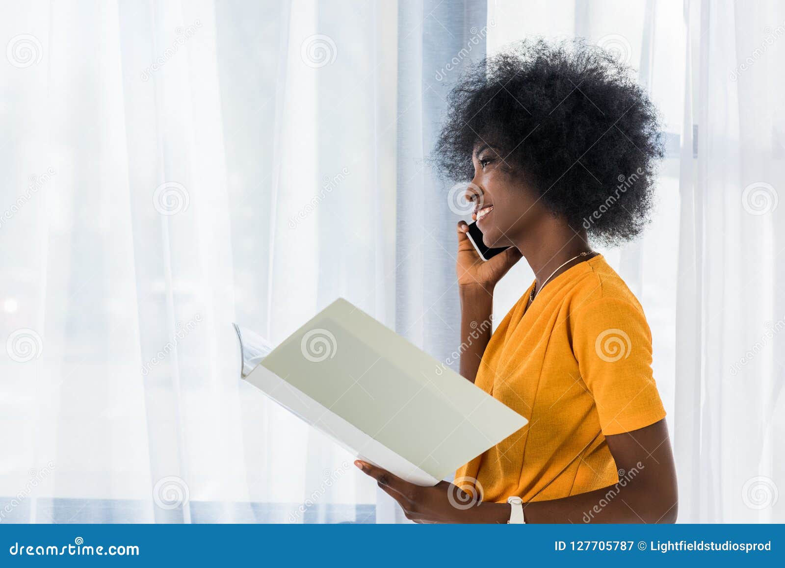 Side View of African American Freelancer with Folder Talking on ... Side View of African American Freelancer with Folder Talking on ...