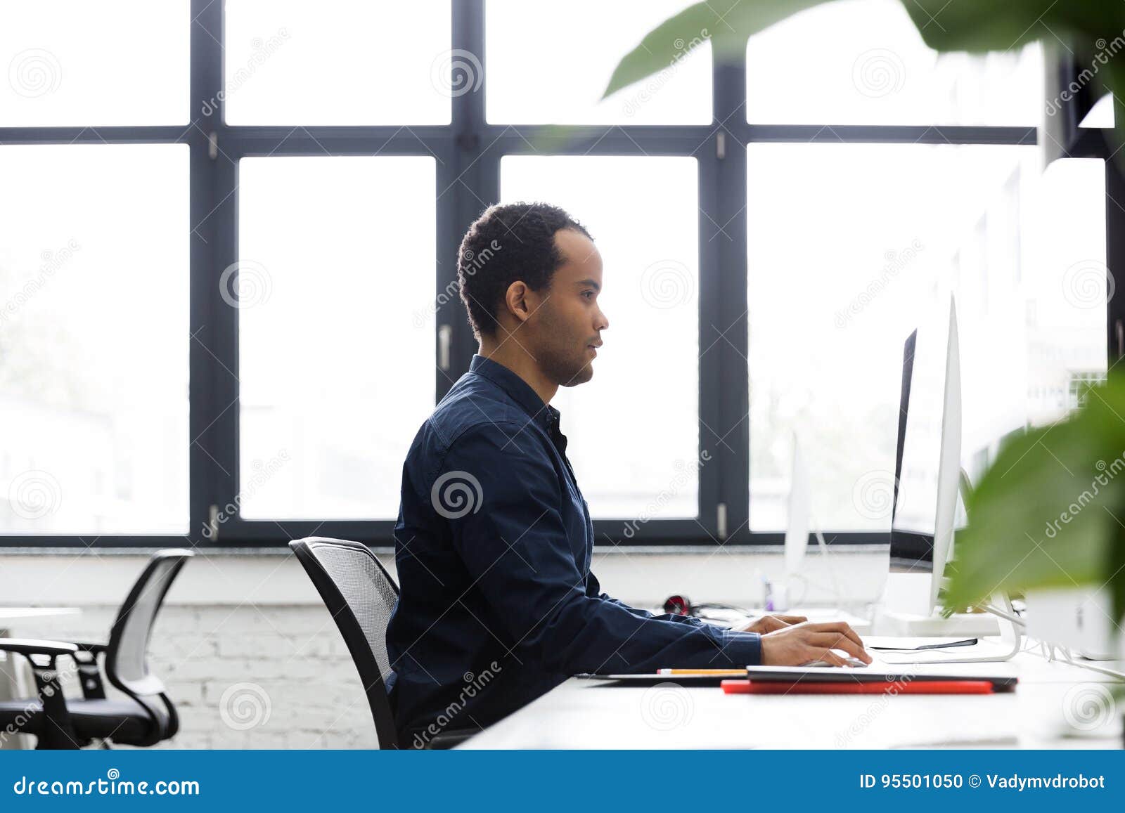 Side View of a African Businessman Working on a Computer Stock Photo ...