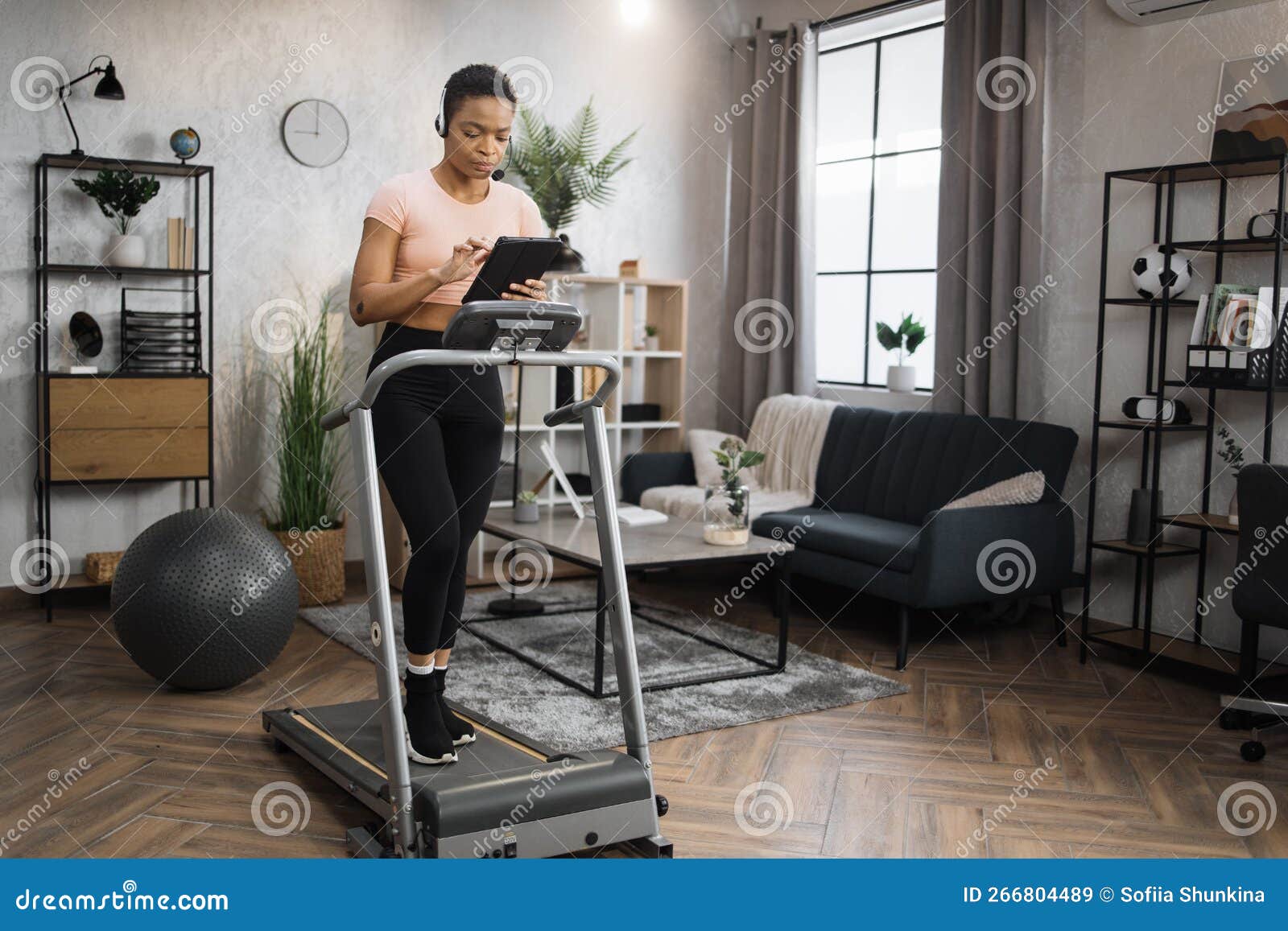 Side View of African Woman in Sport Clothes Using Headset Working on ...