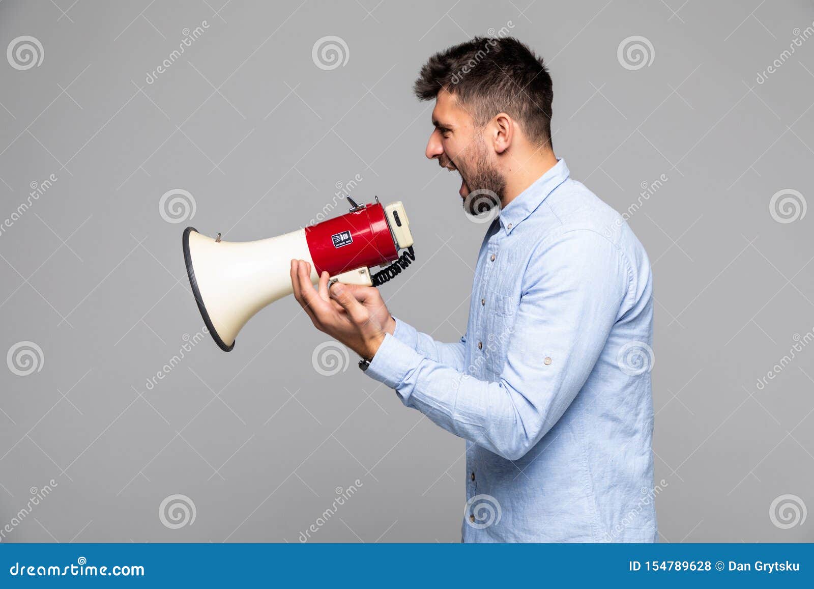 Side View of Angry Man Shouting through Megaphone Against Gray ...