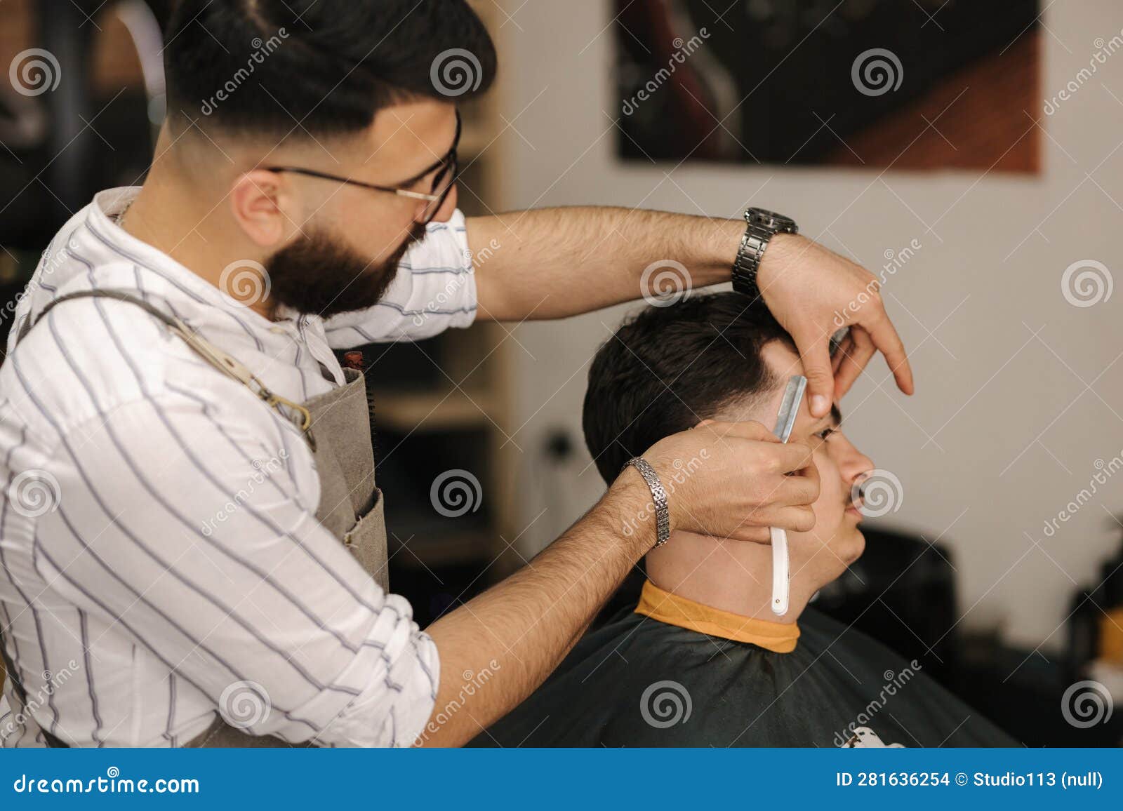 Side View of Barber Using Sharp Blade for Shaving. Handsome Customer ...