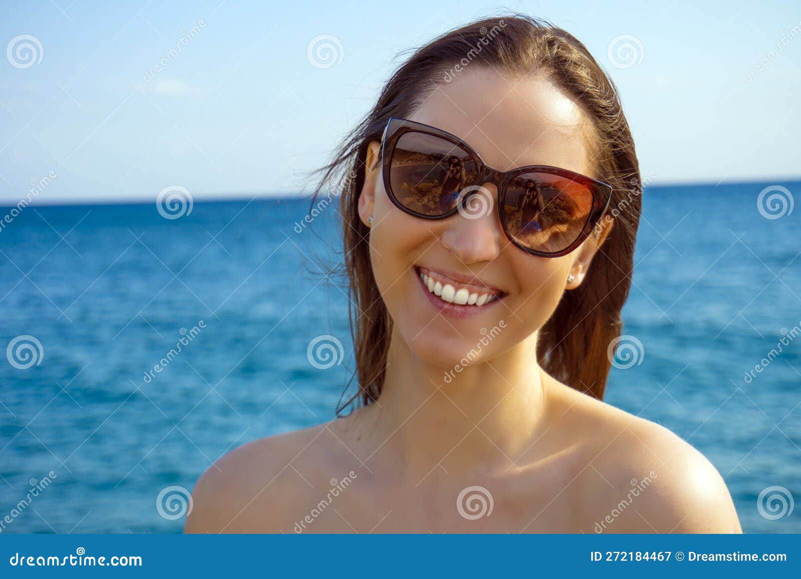 Side View Of Beautiful Mature Woman Wearing Sunglasses At Beach Stock