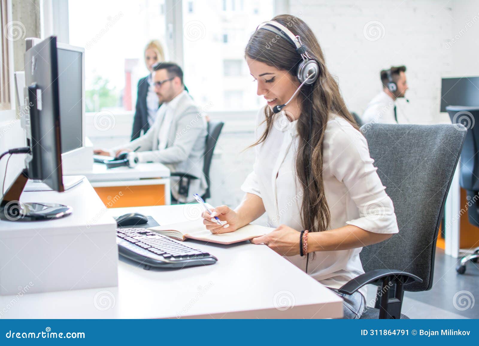 Customer Support Worker Taking Notes while Talking with Client Via ...