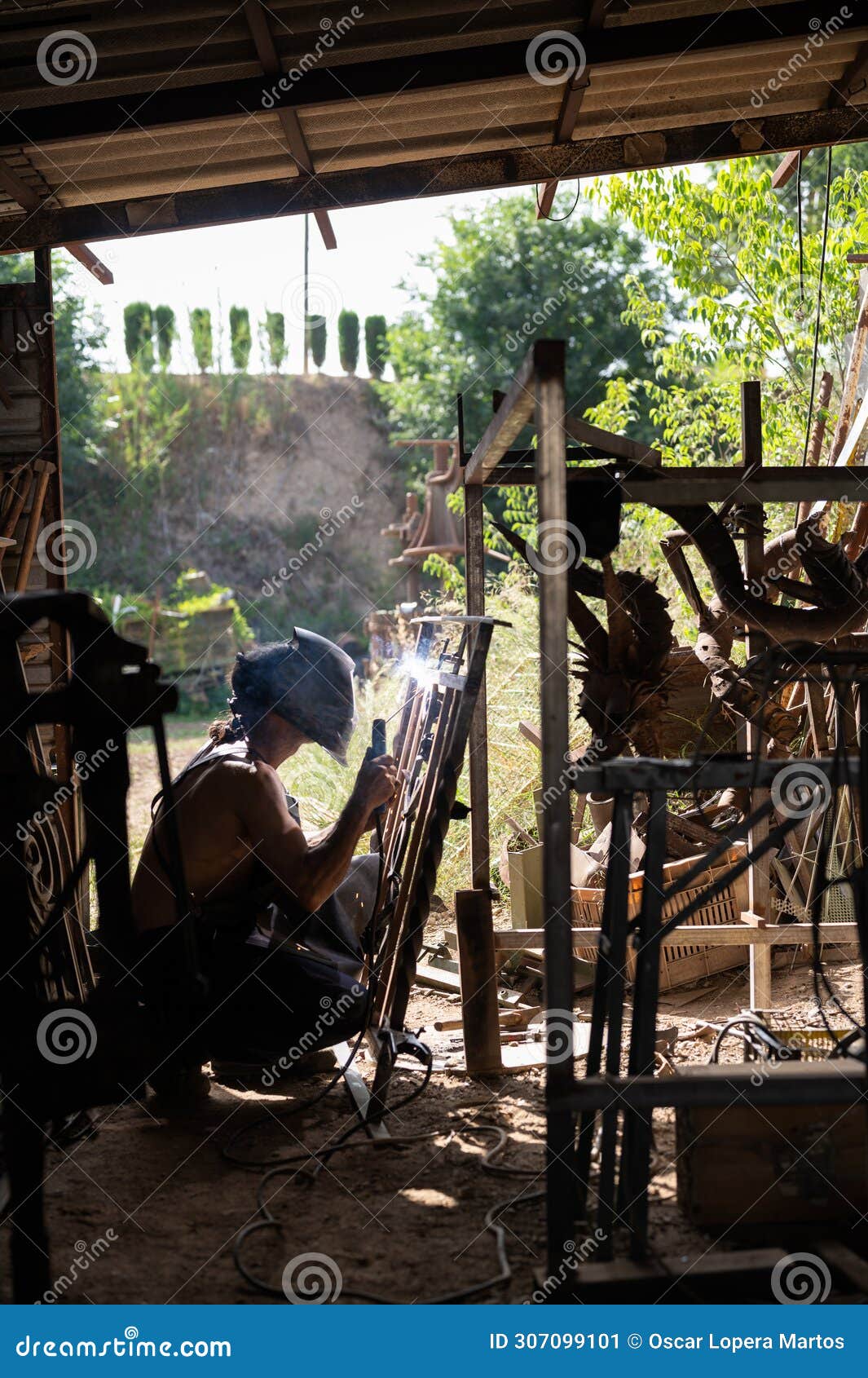 Side View of Blacksmith Welding a Piece of Iron in His Home Workshop ...