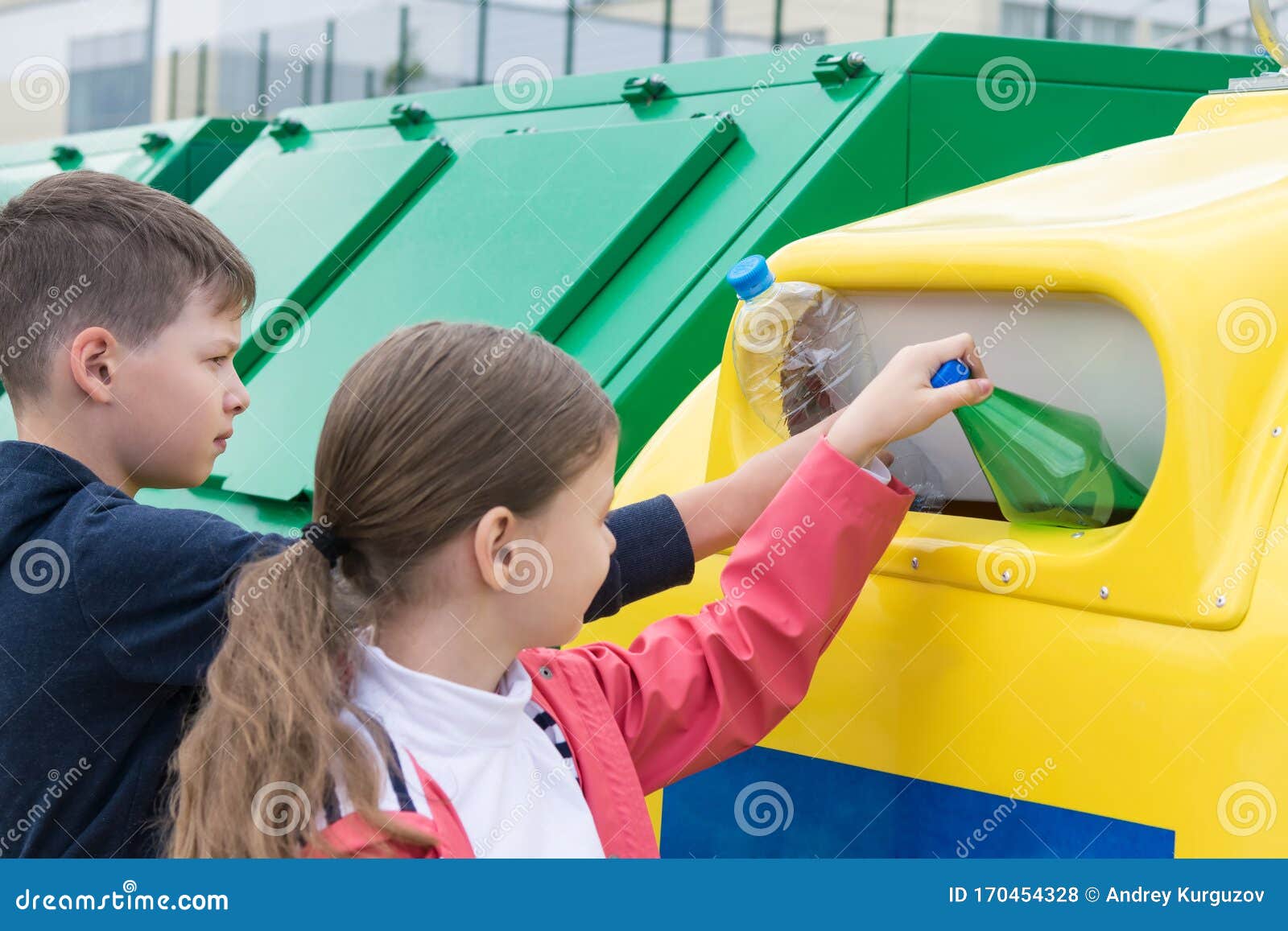 Side View of a Boy and a Girl Throwing Trash into a Container on the ...