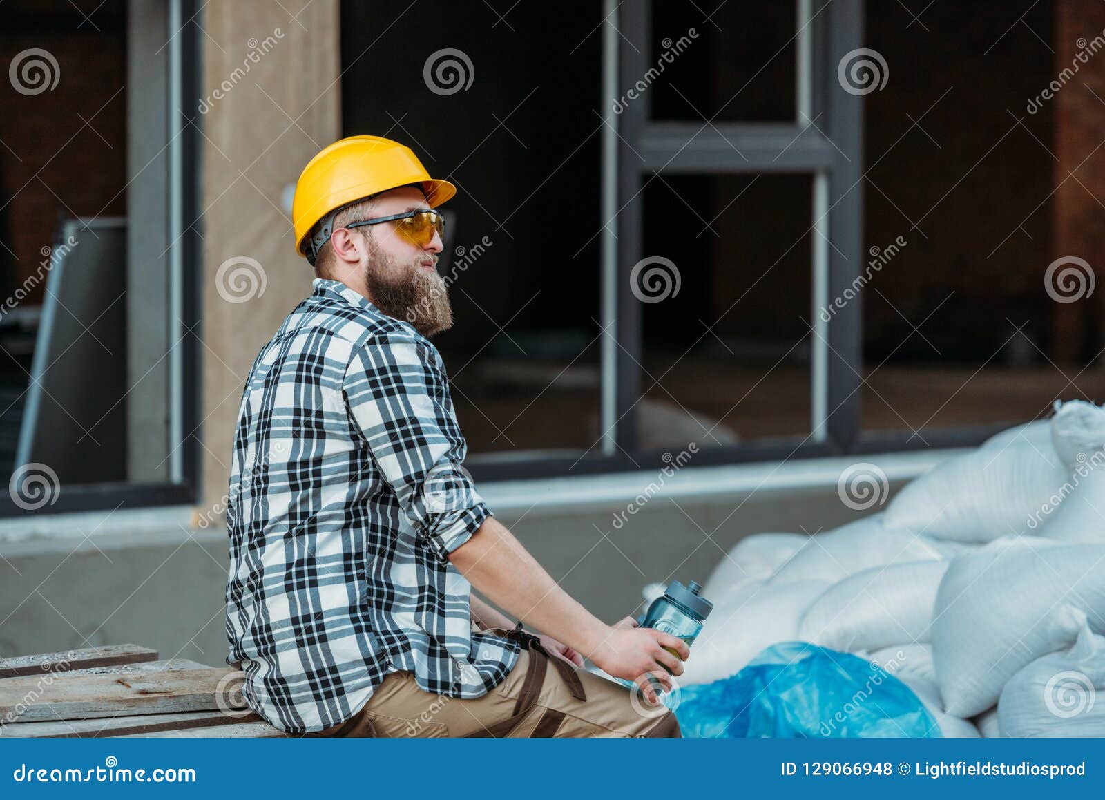 Side View of Builder in Protective Googles and Hardhat Resting with ...