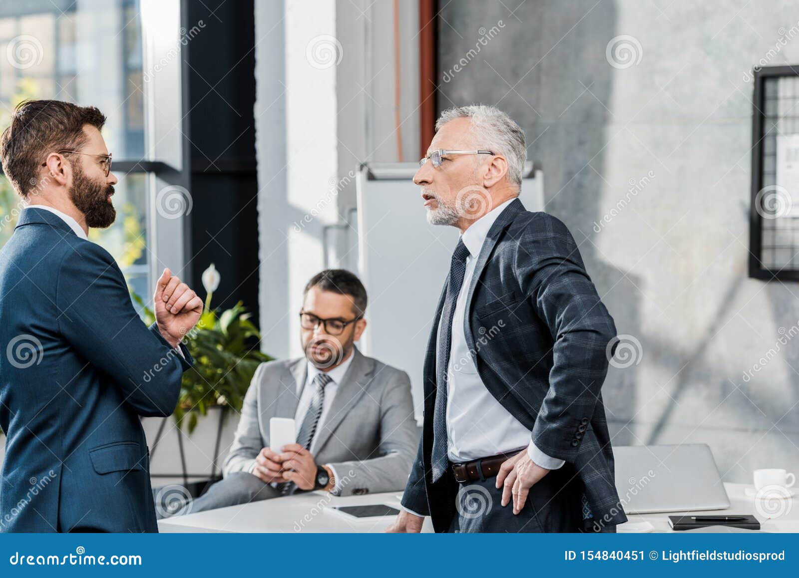 Side View of Businessmen Talking while Standing Stock Image - Image of ...