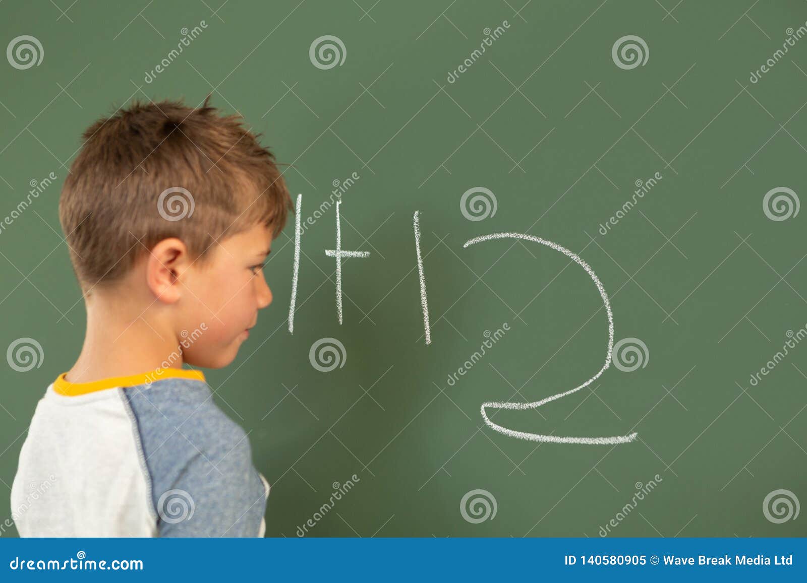 Schoolboy Doing Math on Green Chalkboard in a Classroom Stock Image ...