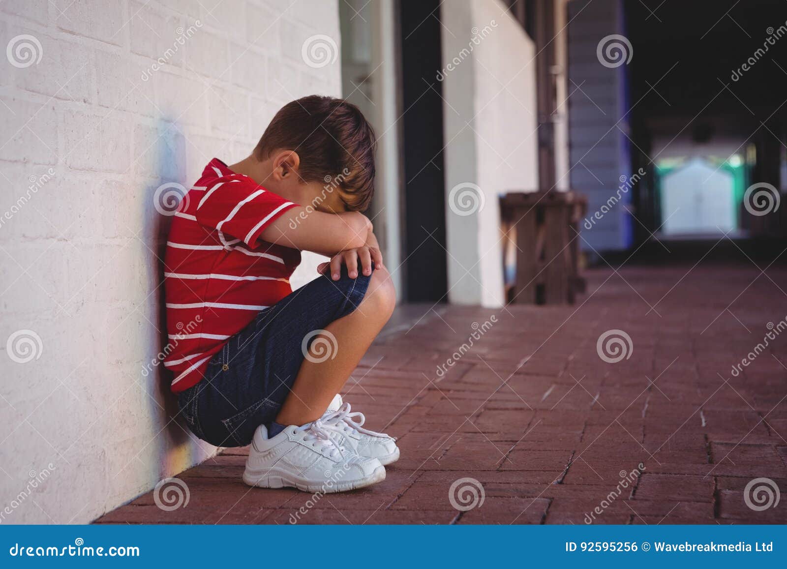 Side View of Depressed Boy Crouching by Wall Stock Photo - Image of ...