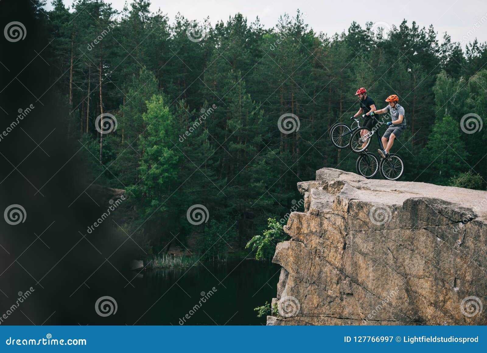 Side View of Extreme Trial Bikers Standing on Back Wheels on Rocky ...