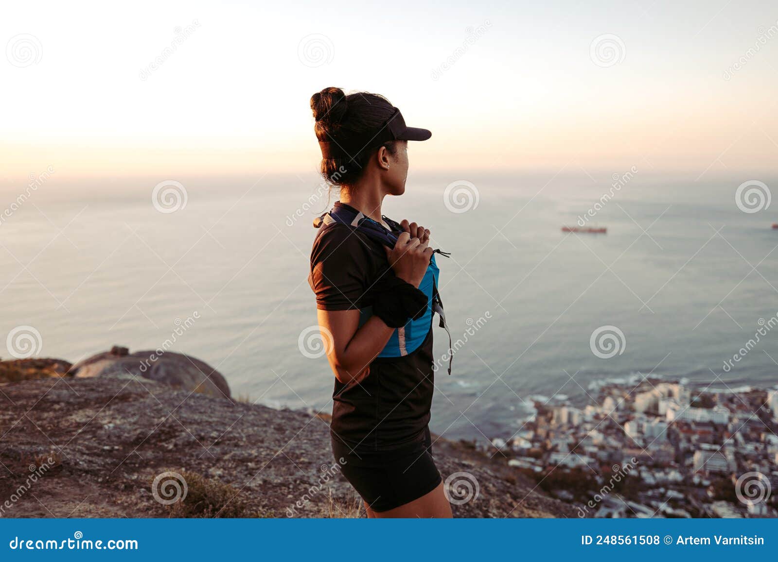 Side View of Female Hiker Looking at the Ocean at Sunset from the Top ...