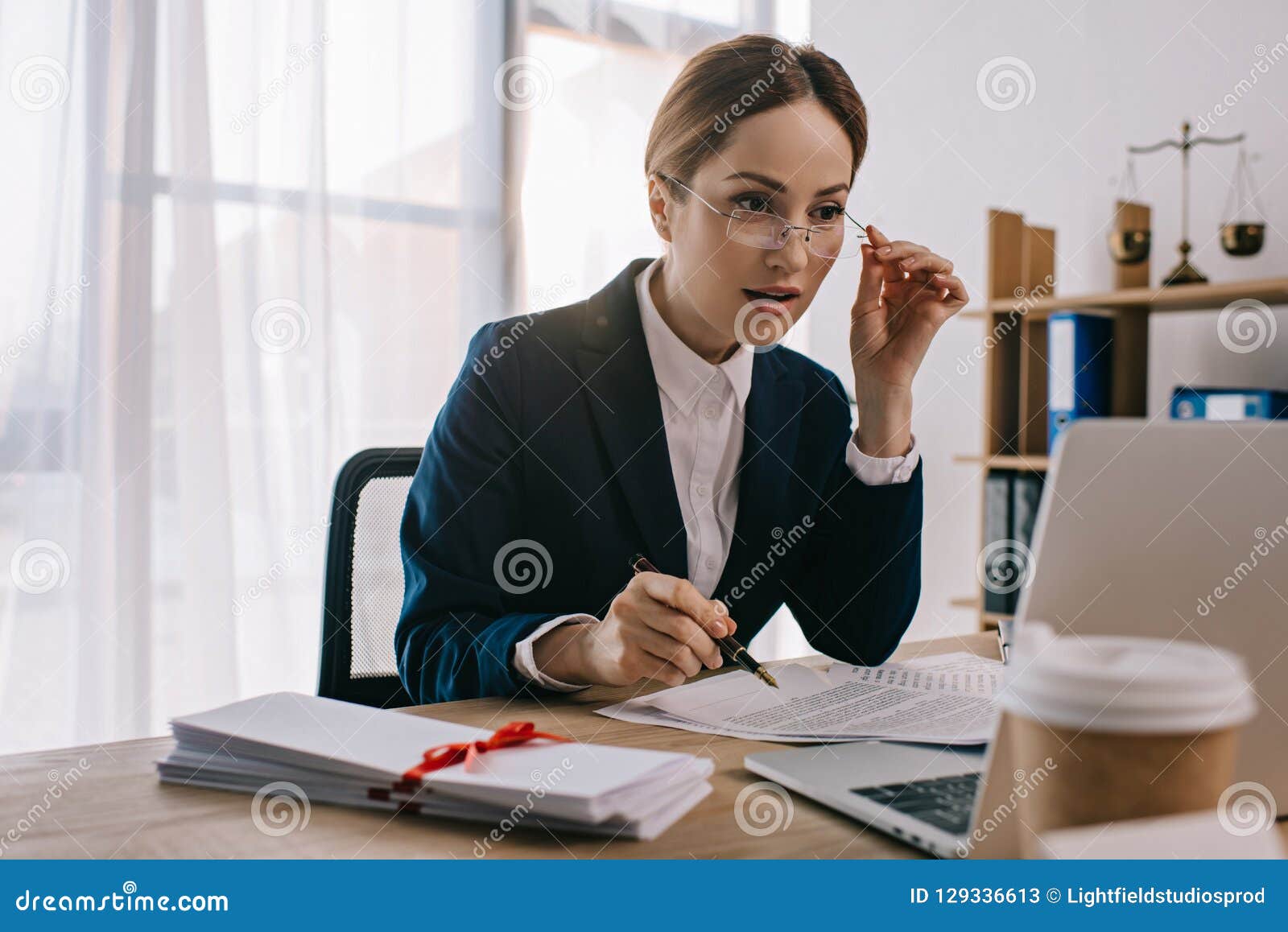 Side View of Female Lawyer Doing Paperwork at Workplace with Laptop ...