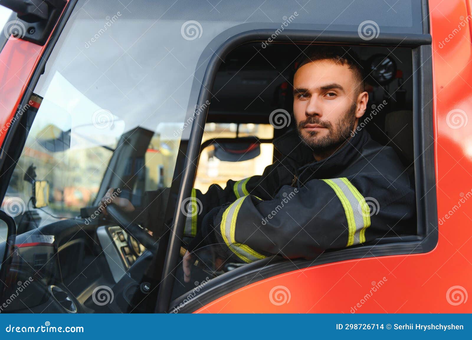 Side View of Firefighter in Protective Uniform Driving Fire Engine ...